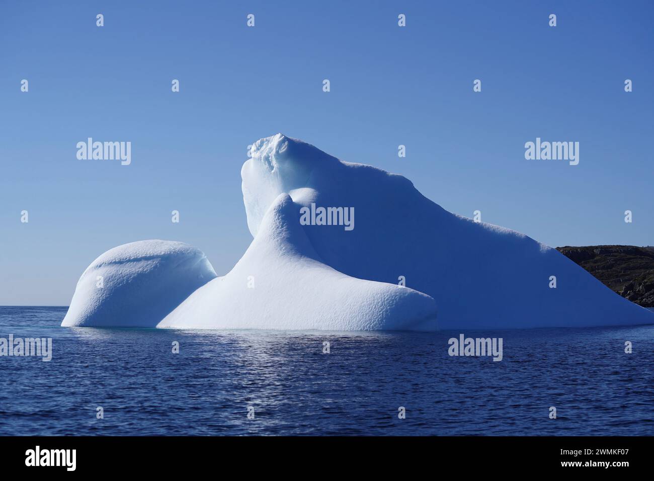 Pinnacle iceberg along a coast under a blue sky Stock Photo - Alamy