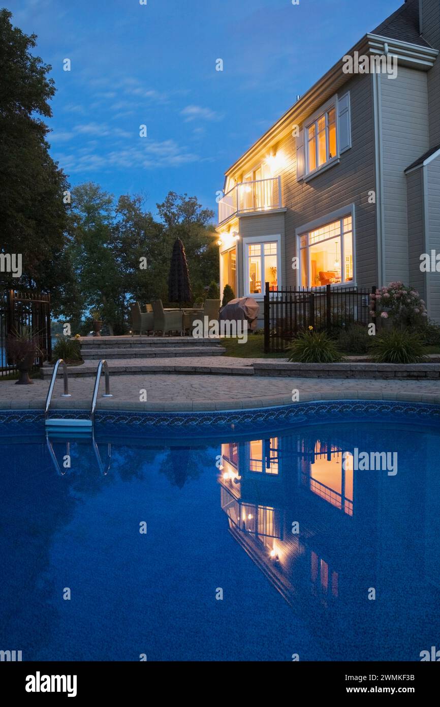 Modern two story tan clapboard cladded home with landscaped backyard ...