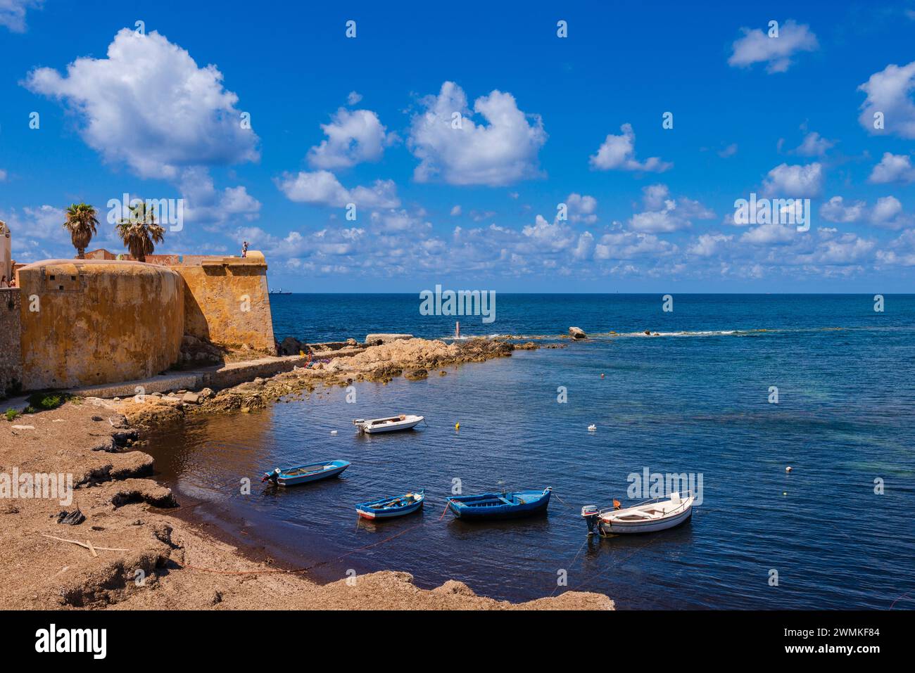 Small boats moored along the shore of the Old Town of Trapani by the ...