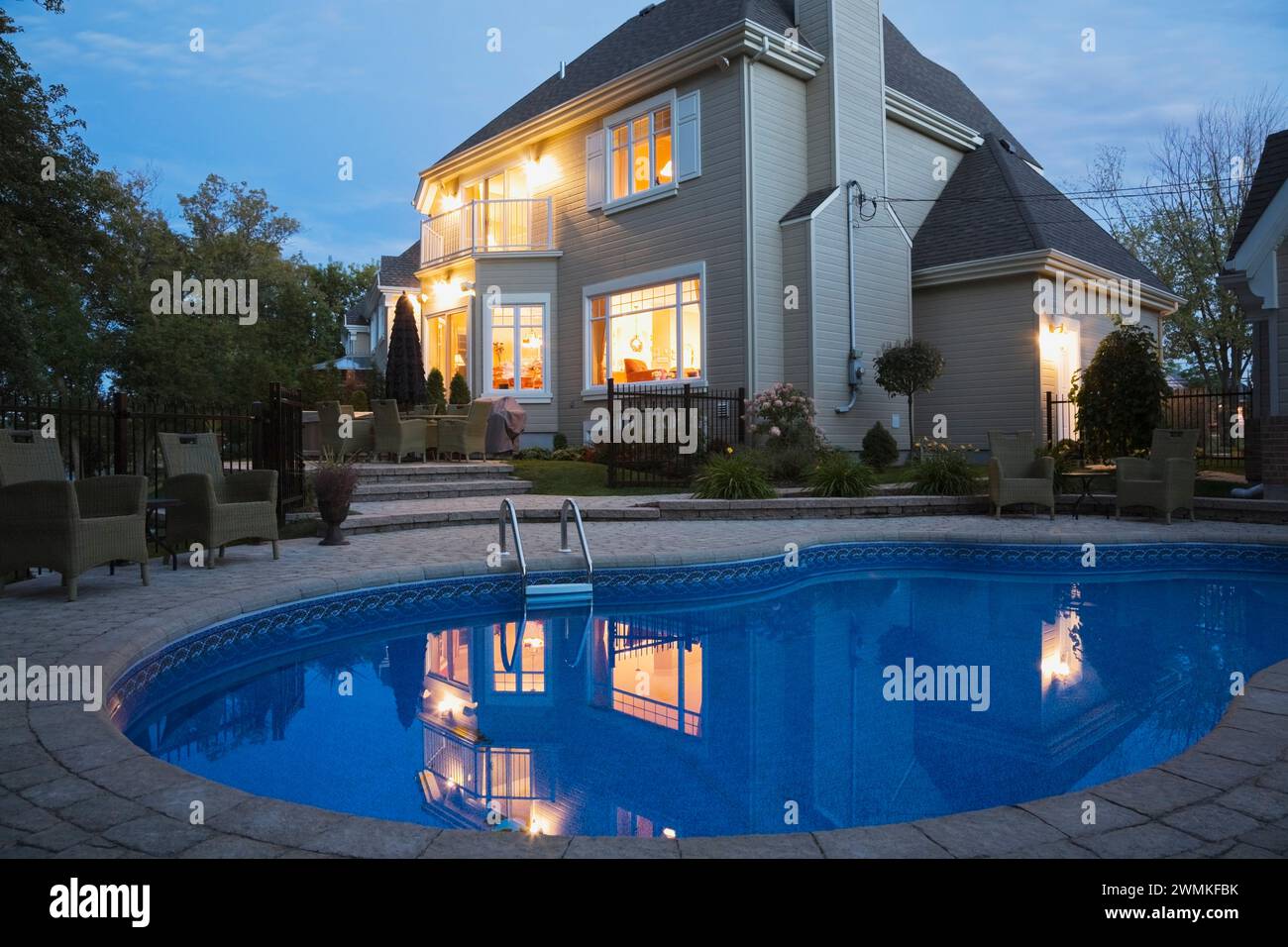 Modern two story tan clapboard cladded home with landscaped backyard ...