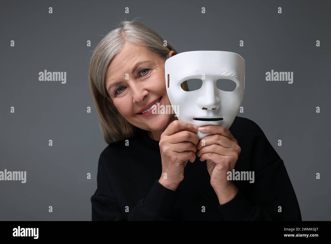 Multiple personality concept. Woman with mask on gray background Stock ...