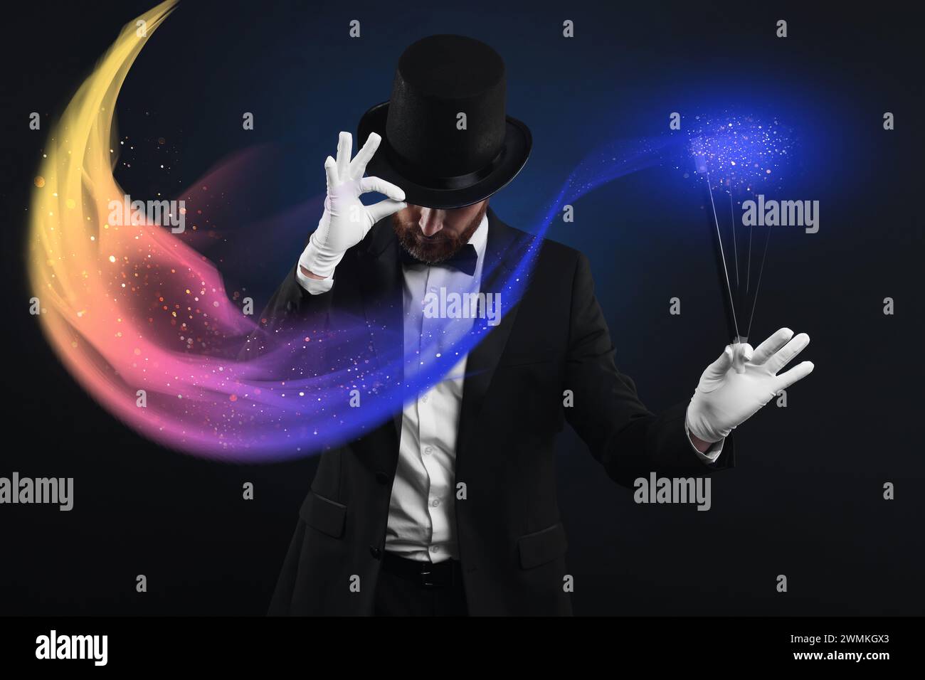 Magic and sorcery. Magician with wand and fantastic light on dark ...