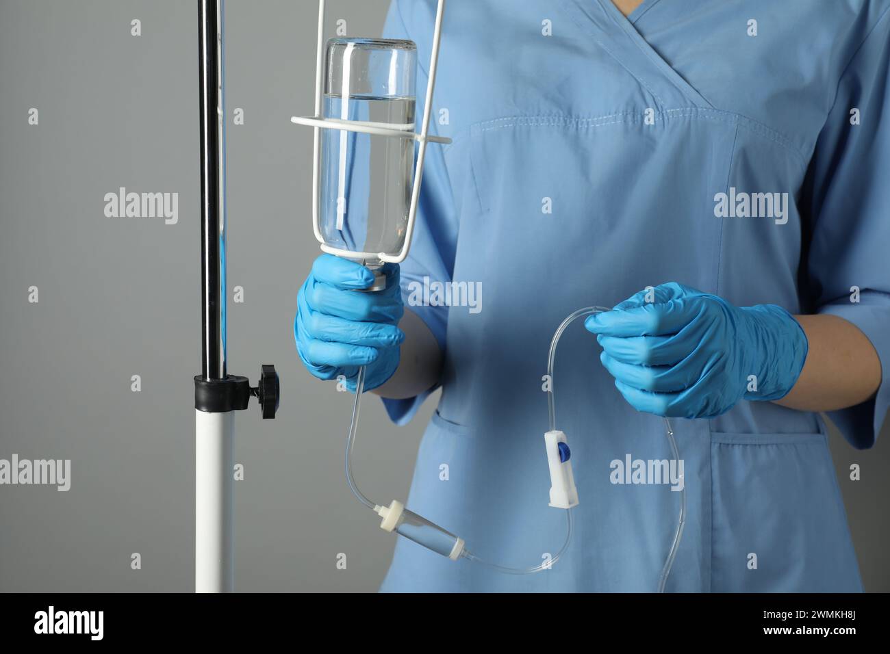 Nurse with IV infusion set on grey background, closeup Stock Photo - Alamy