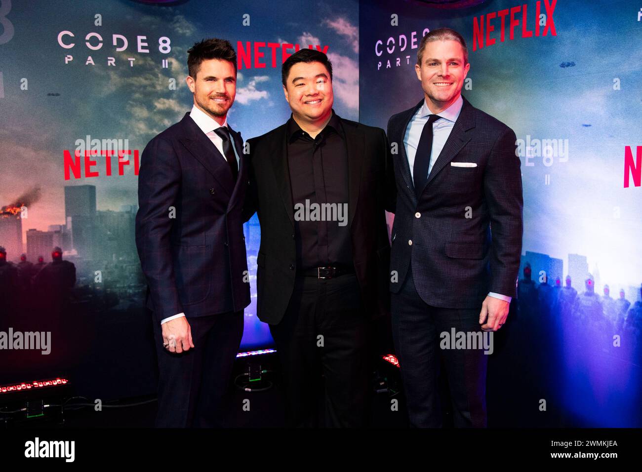 From left, Robbie Amell, director Jeff Chan and Stephen Amell arrive at the premiere of "Code 8 ...