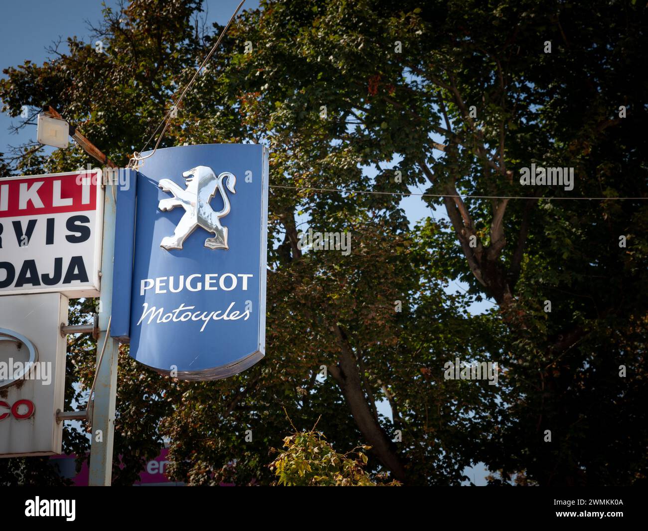Picture of a sign with the logo of Peugeot Motocycles on their main ...