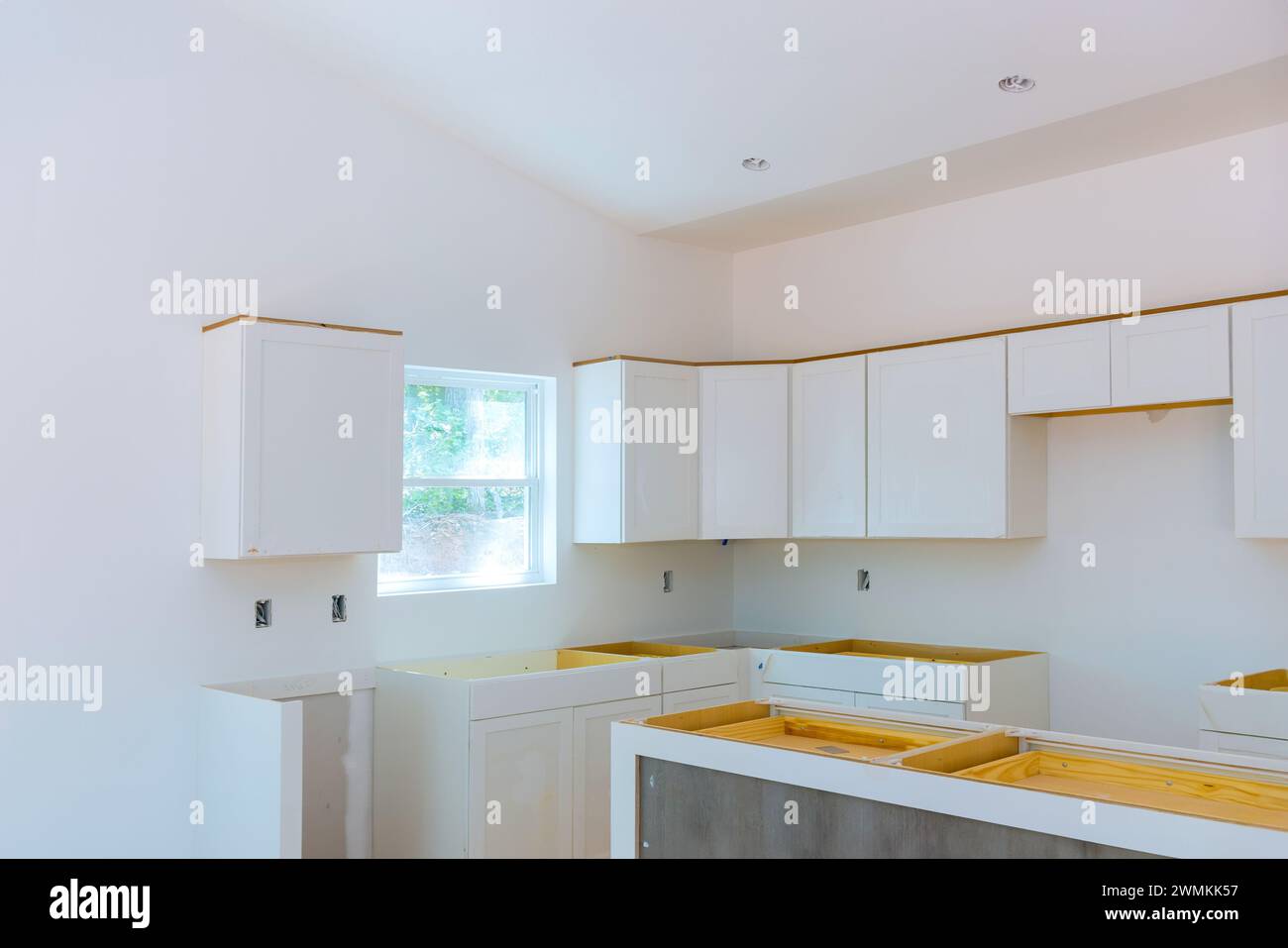 Kitchen cabinets made of wood white are being installed in newly ...