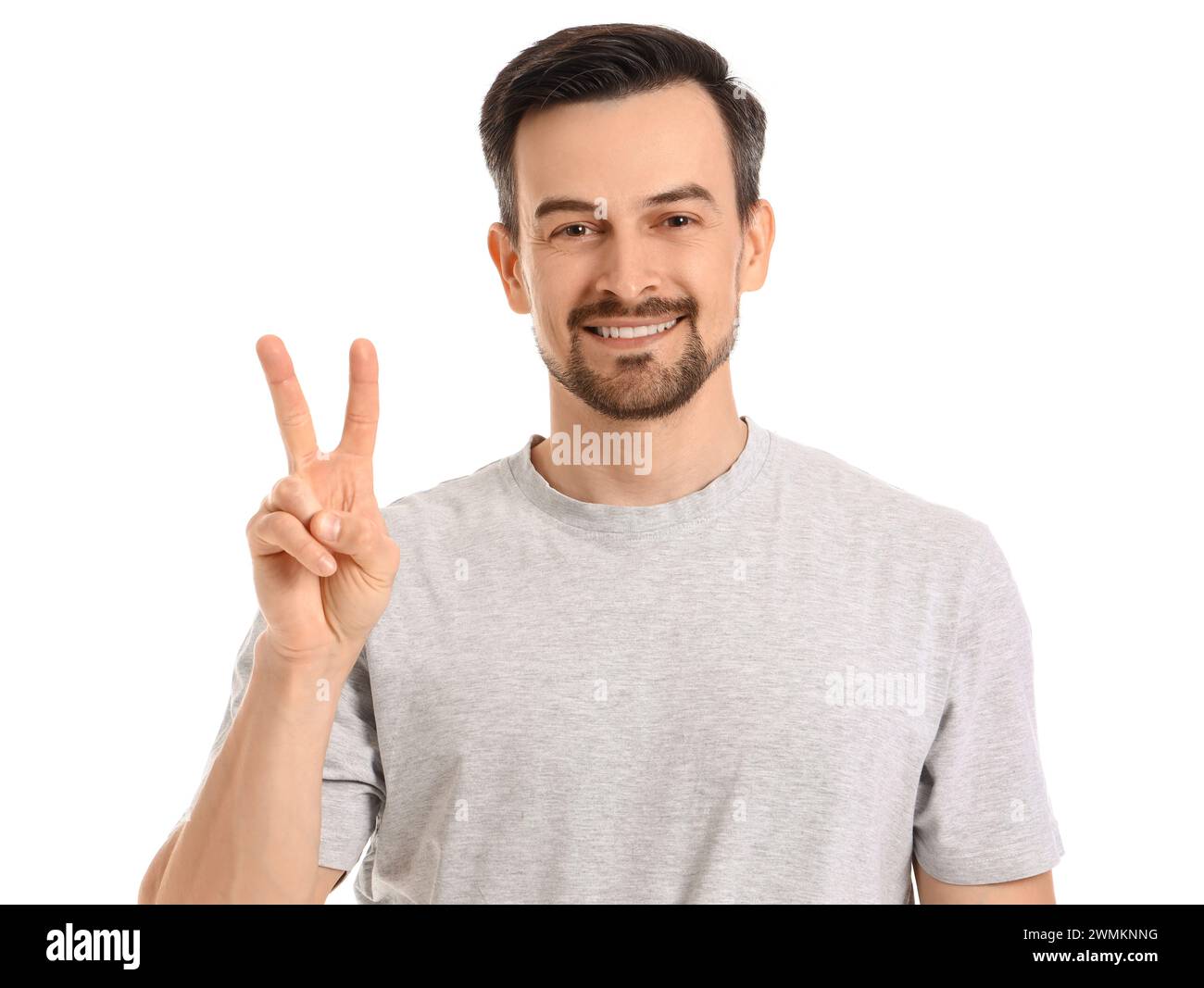 Handsome man showing victory gesture on white background Stock Photo ...