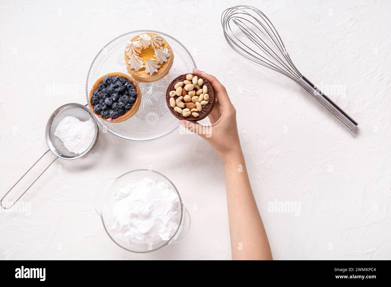 Female confectioner with tasty cakes on white background Stock Photo ...