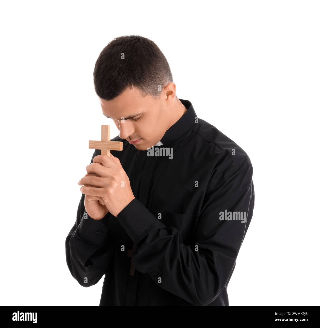 Young priest with cross praying on white background Stock Photo - Alamy
