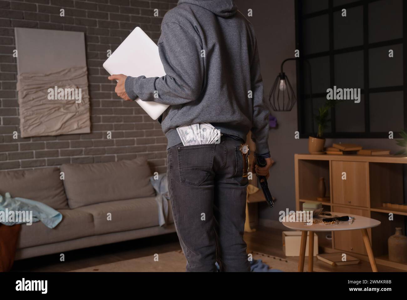 Male thief with stolen valuables in room at night, back view Stock ...