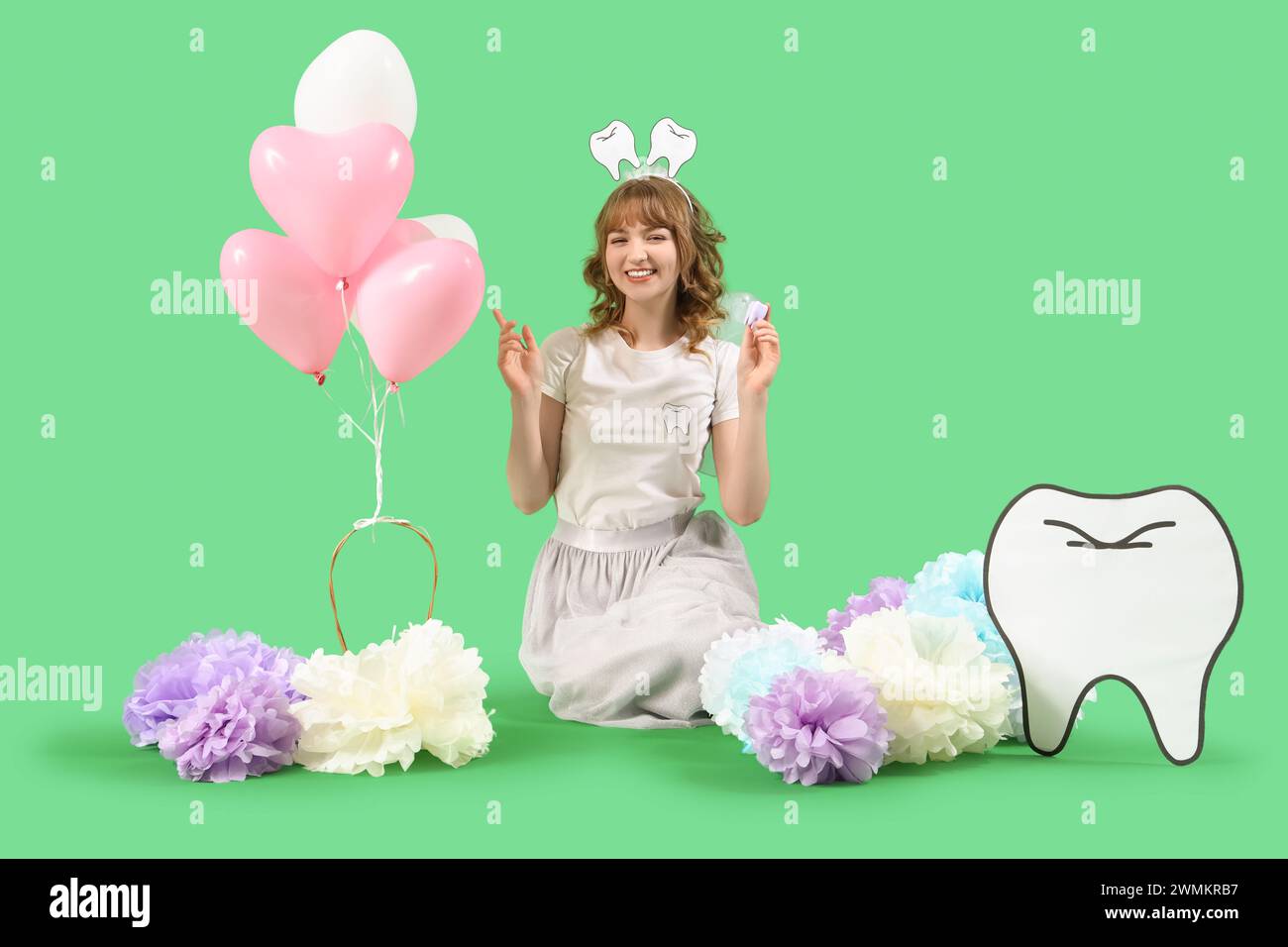 Tooth Fairy with plastic figure and balloons on green background Stock ...