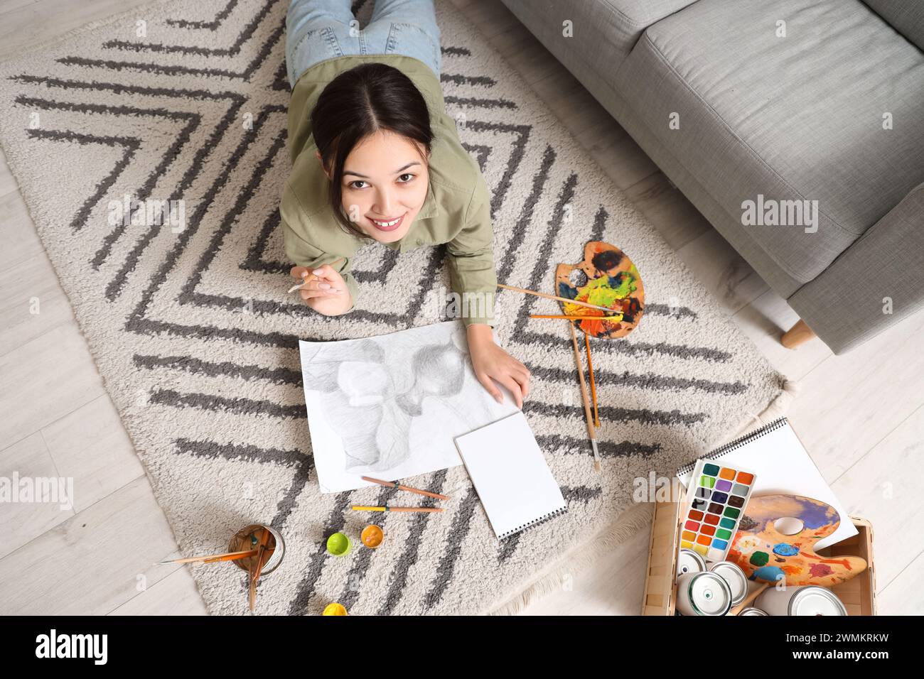 Female Asian artist drawing on floor in workshop, top view Stock Photo ...