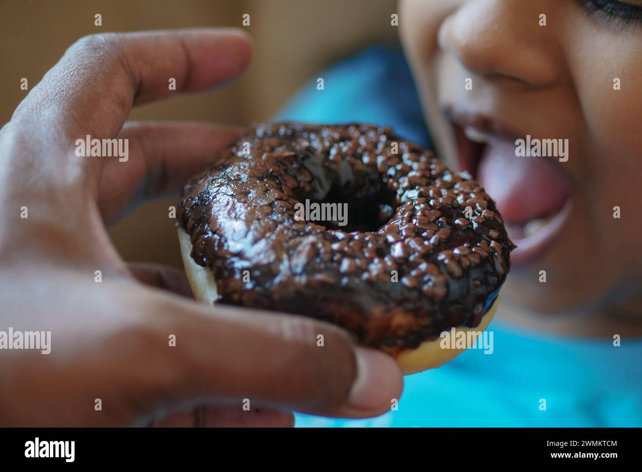 child mouth eating chocolate donuts Stock Photo - Alamy