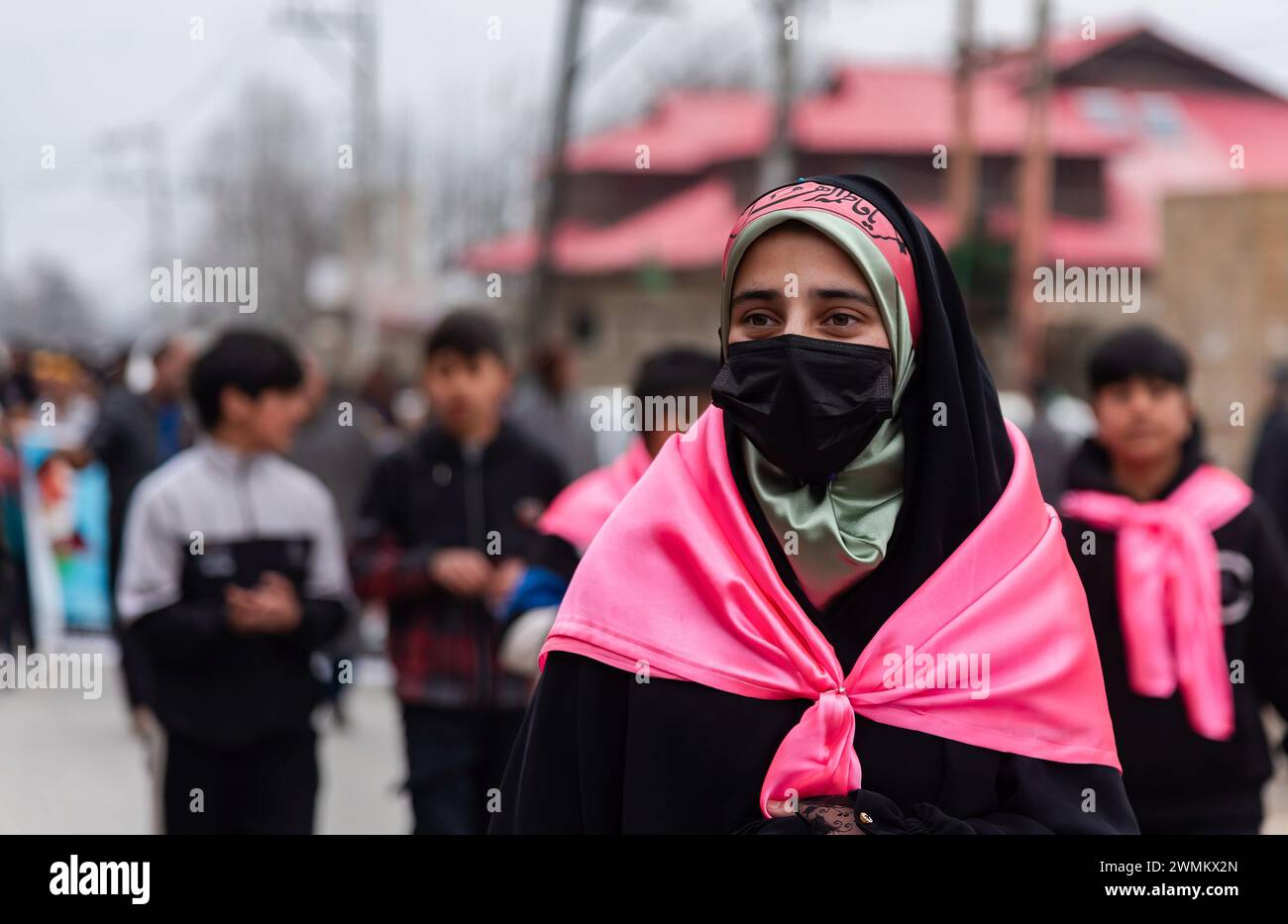 Budgam, India. 26th Feb, 2024. A Kashmiri Shia Muslim girl looks on as ...