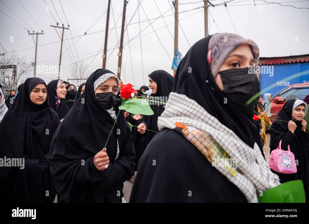 Budgam, India. 26th Feb, 2024. Kashmiri Shia Muslims hold flowers as ...