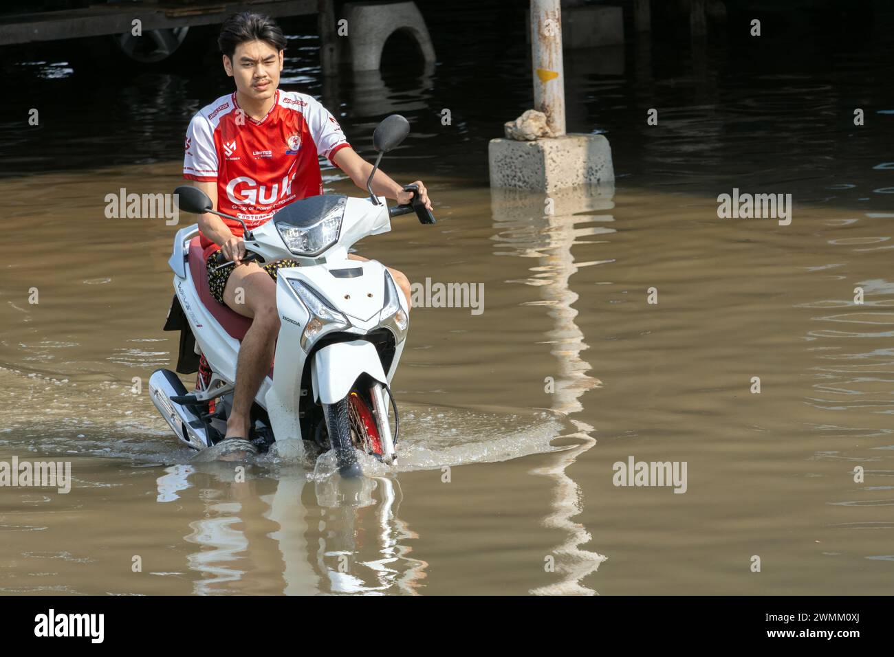 SAMUT PRAKAN, THAILAND, FEB 02 2024, A motorbike rides on a flooded street Stock Photo - Alamy