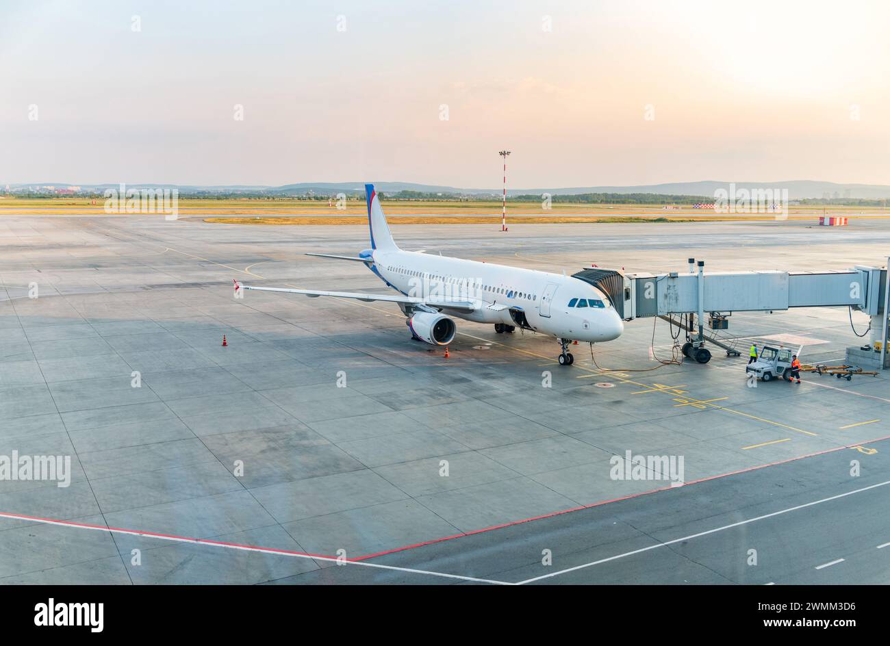 Passenger plane on the airfield connected to walkway.The gate sleeve is ...