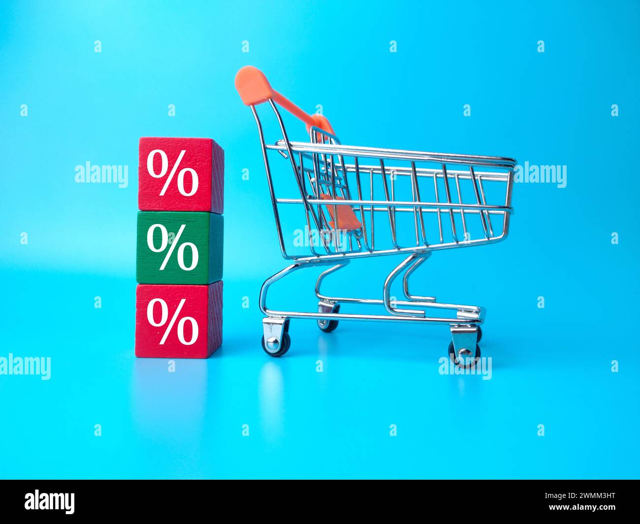 Shopping chart and wooden block with persentage symbol on blue ...