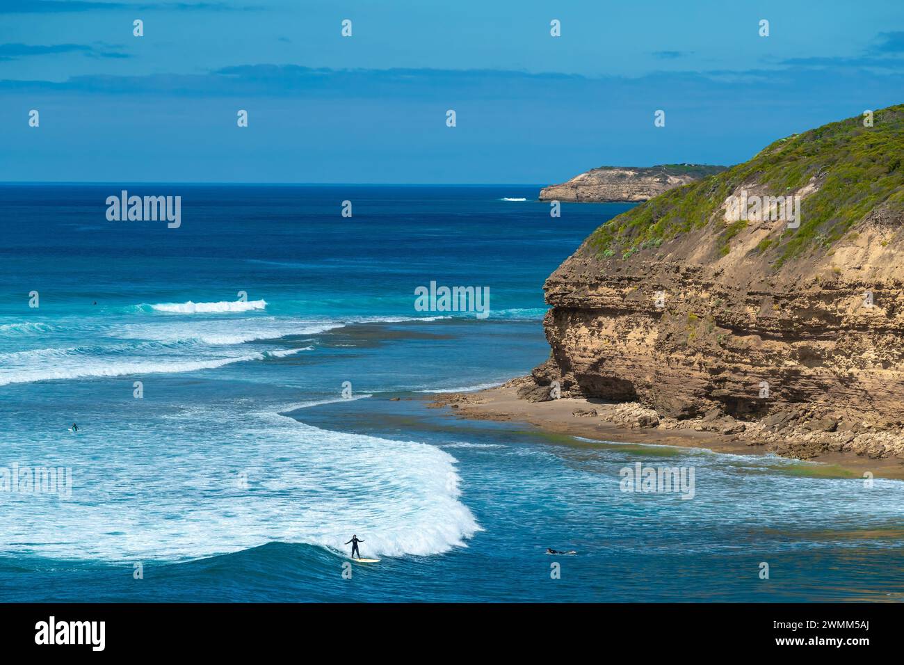 Surfers and the rugged coastline of Bells Beach in Victoria, Australia ...