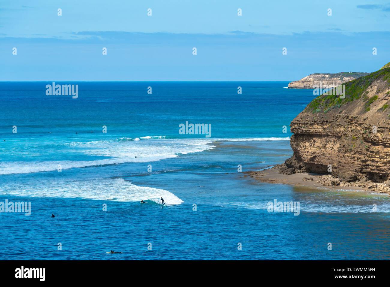 Surfers and the rugged coastline of Bells Beach in Victoria, Australia ...