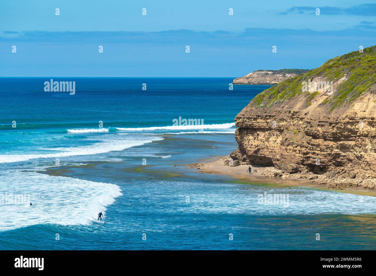 Surfers and the rugged coastline of Bells Beach in Victoria, Australia ...