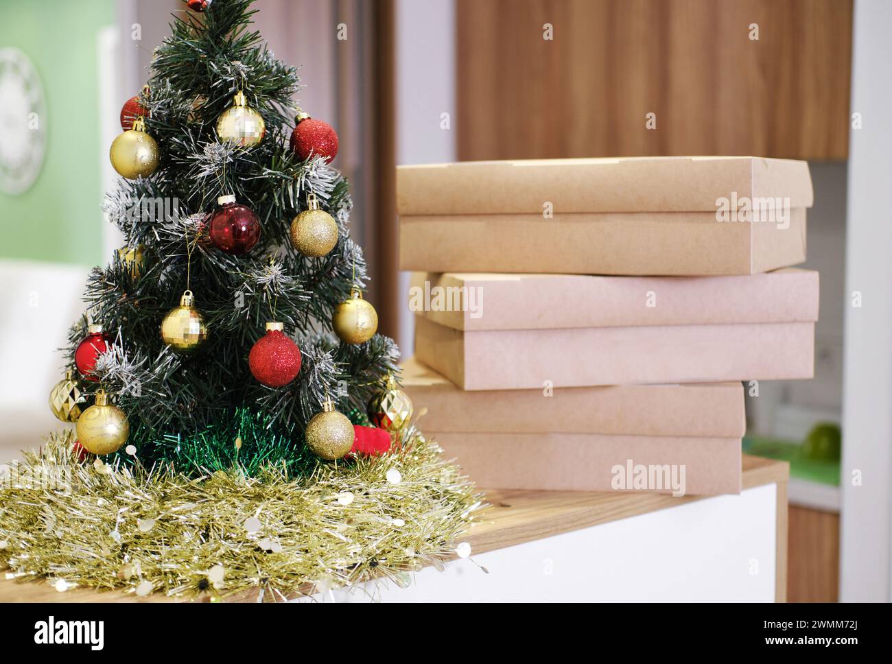 A decorated Christmas tree stands beside a stack of cardboard food ...
