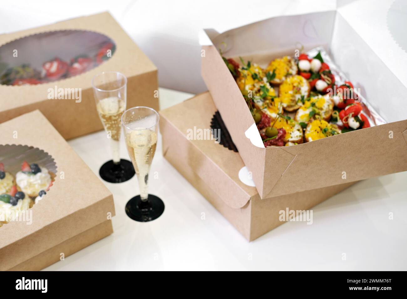 An array of delicious catered dishes in open boxes alongside champagne ...