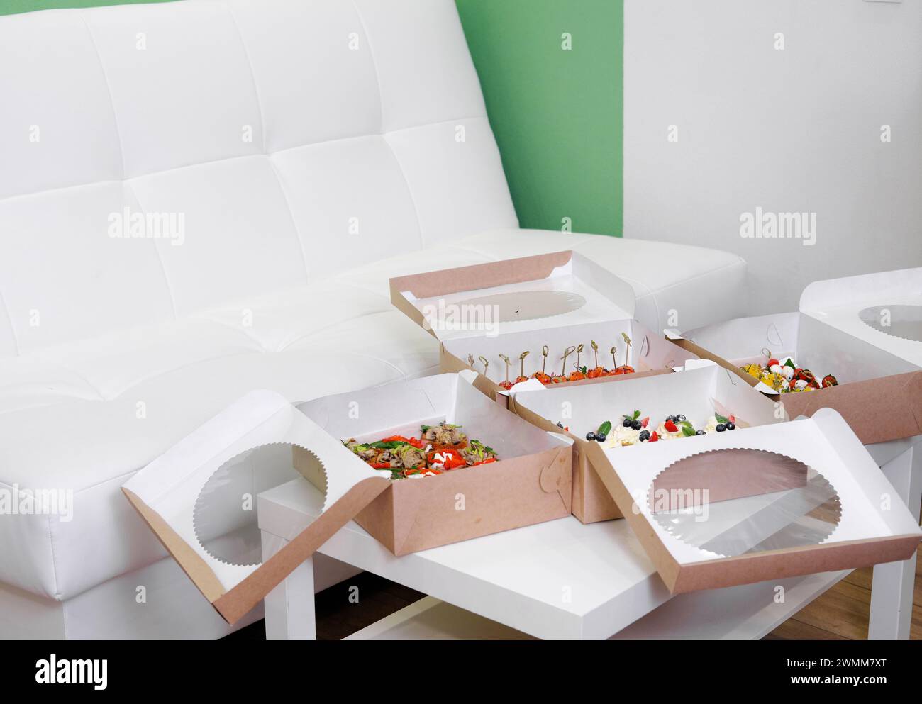 In a minimalist office with white and green walls, a set of snack boxes ...