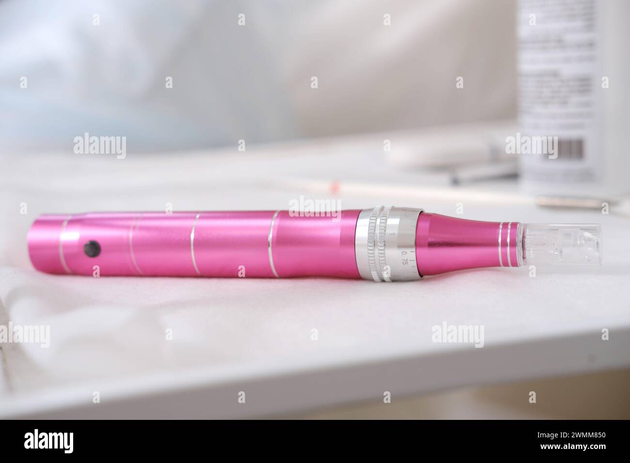 A pink dermapen lies on a clean white table. Horizontal photo Stock ...