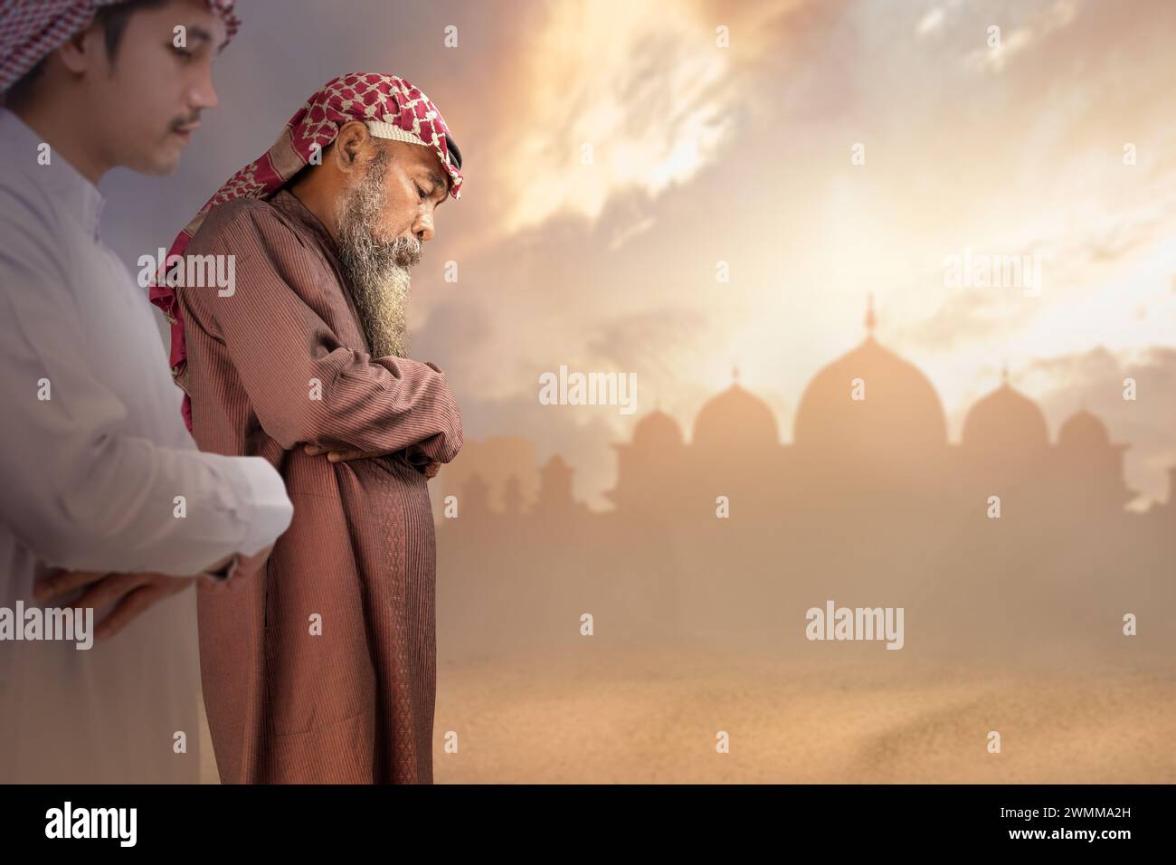 Two Muslim men with agal in a praying position (salat) with a dramatic ...