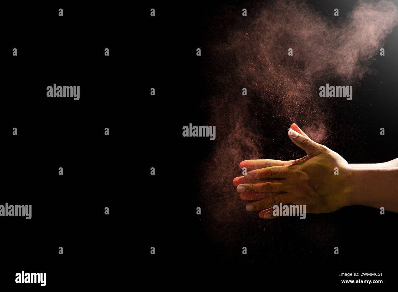 Closeup of hand holding colorful holi powder isolated over black ...