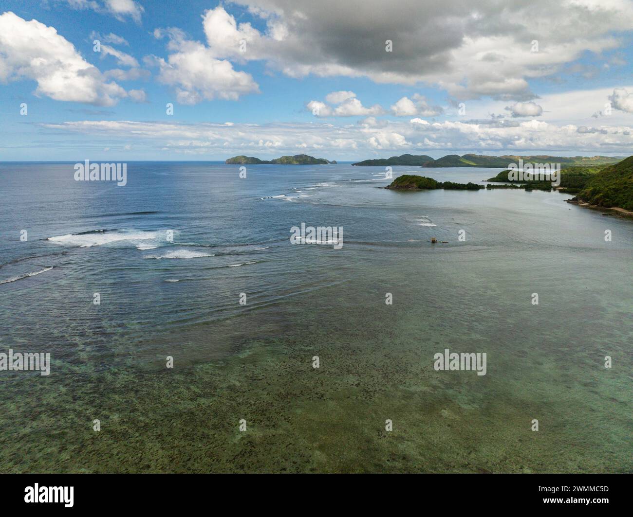 Ocean waves and corals under the blue sky and clouds. Busuanga, Palawan ...