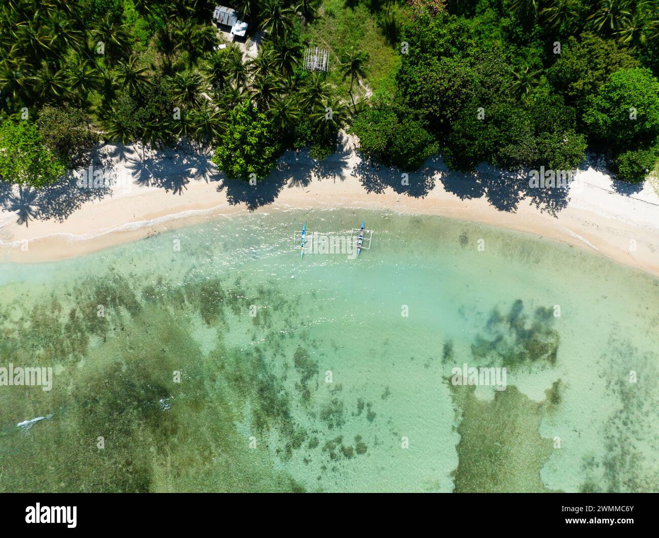 Fishing boat on clear turquoise water, sea waves on sands in tropical ...