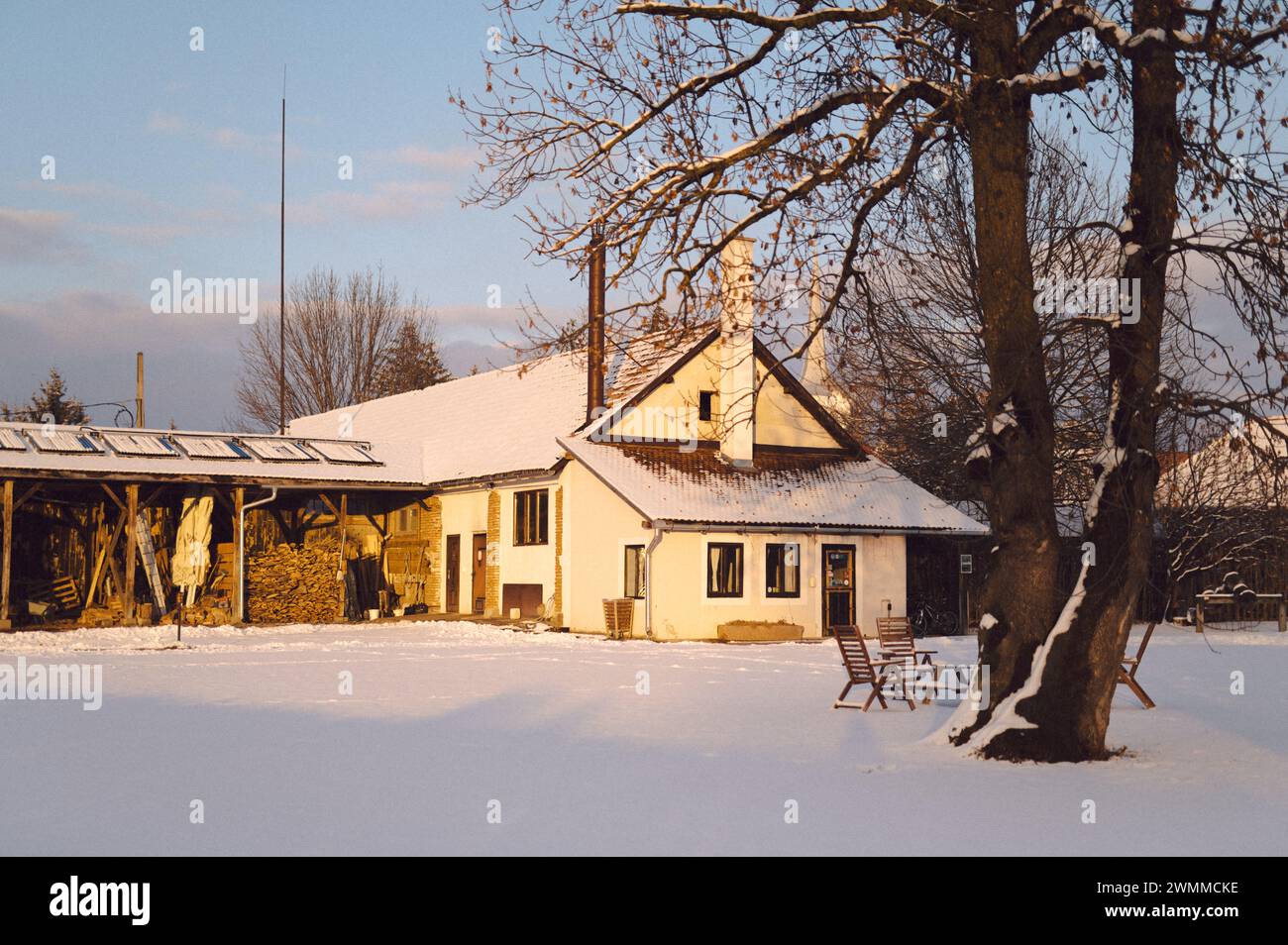 Snowy landscape with two buildings and trees in foreground Stock Photo ...