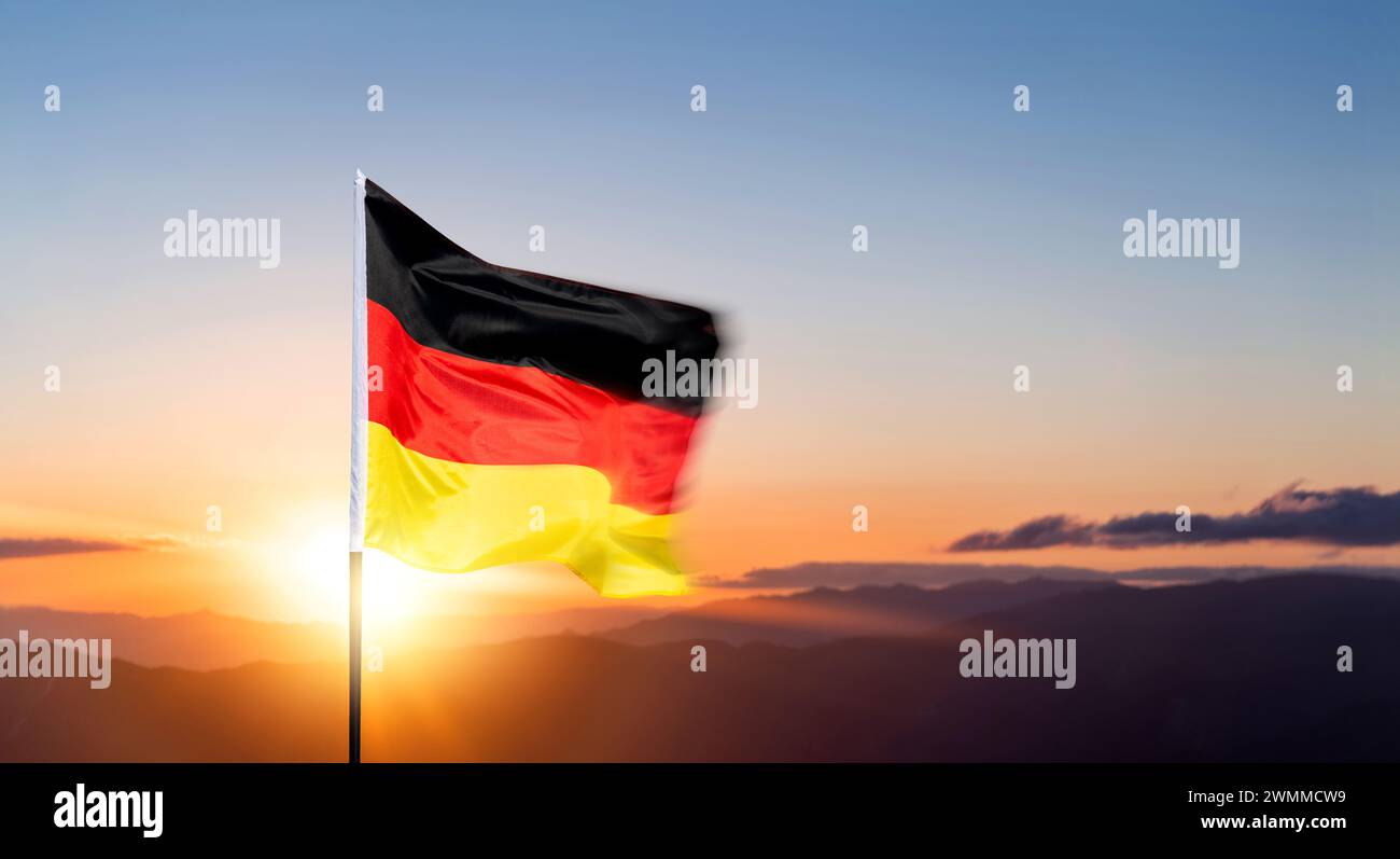 German flag waving against sunrise sky background Stock Photo - Alamy