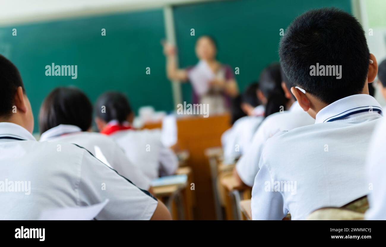 Rear view of students studying in classroom Stock Photo - Alamy