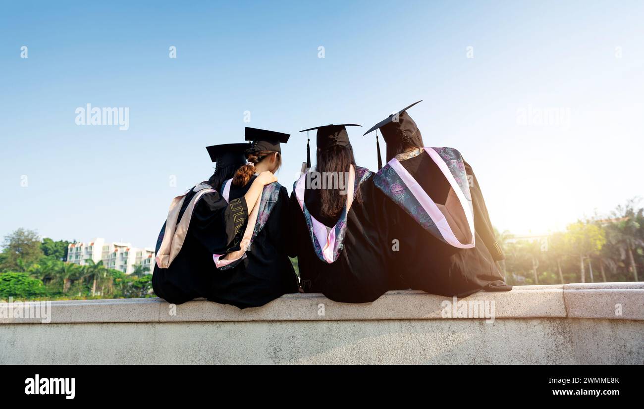 Back view of graduates together against blue sky Stock Photo - Alamy