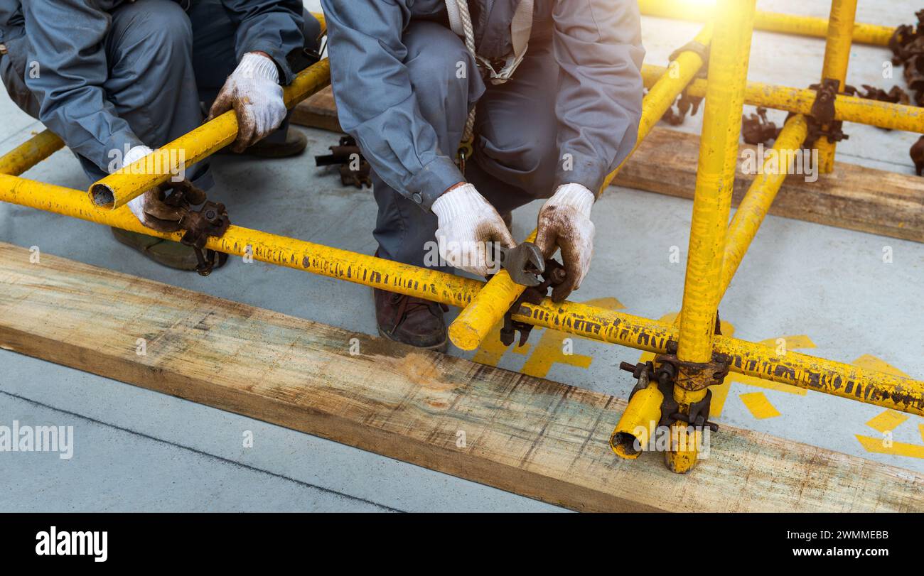Two construction workers working on scaffolding Stock Photo - Alamy