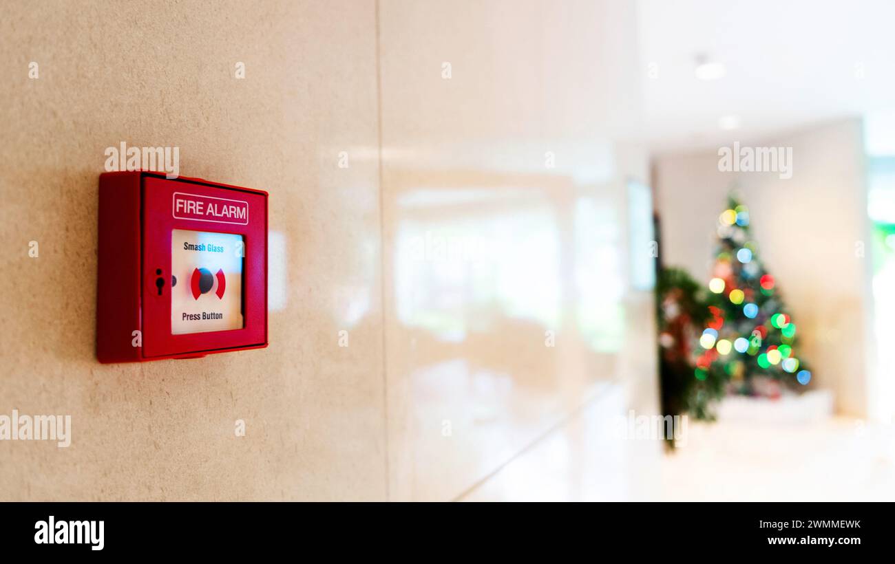 Fire alarm on the wall of hotel with christmas tree in the background ...