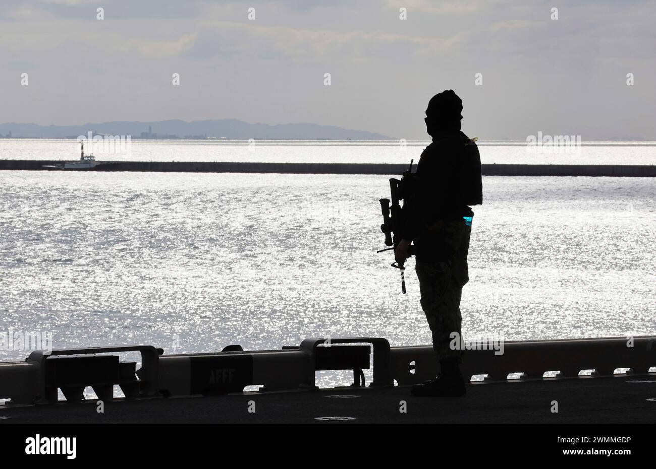 A soldier stands on a flying-off deck of USS America(LHA-6), an ...