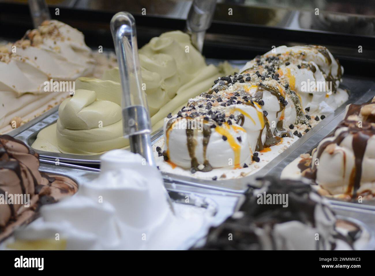 A close-up of various flavors of ice cream displayed in a glass ...