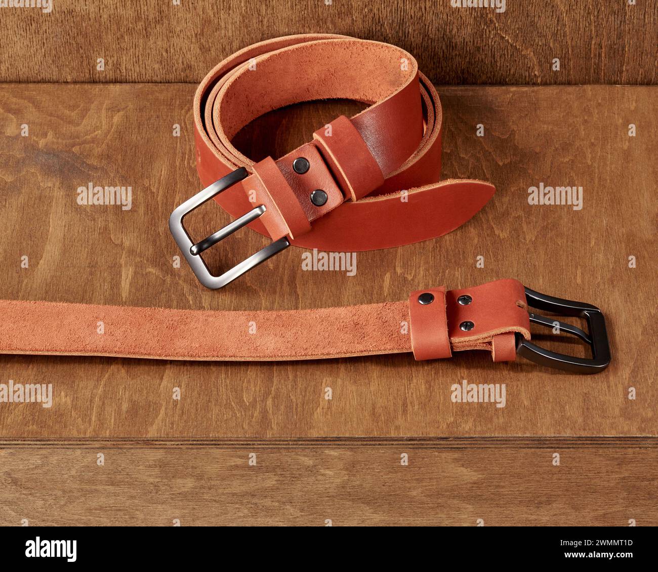 Wooden stand featuring two terracotta leather belts with DAD embossment ...