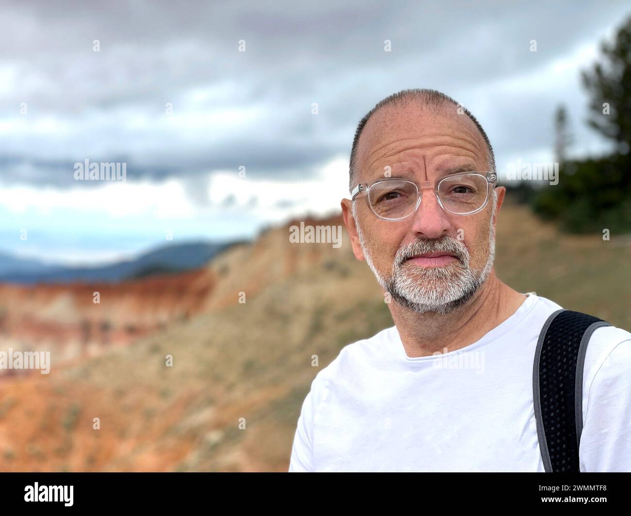 middle aged white man with glasses and white t shirt looking directly ...