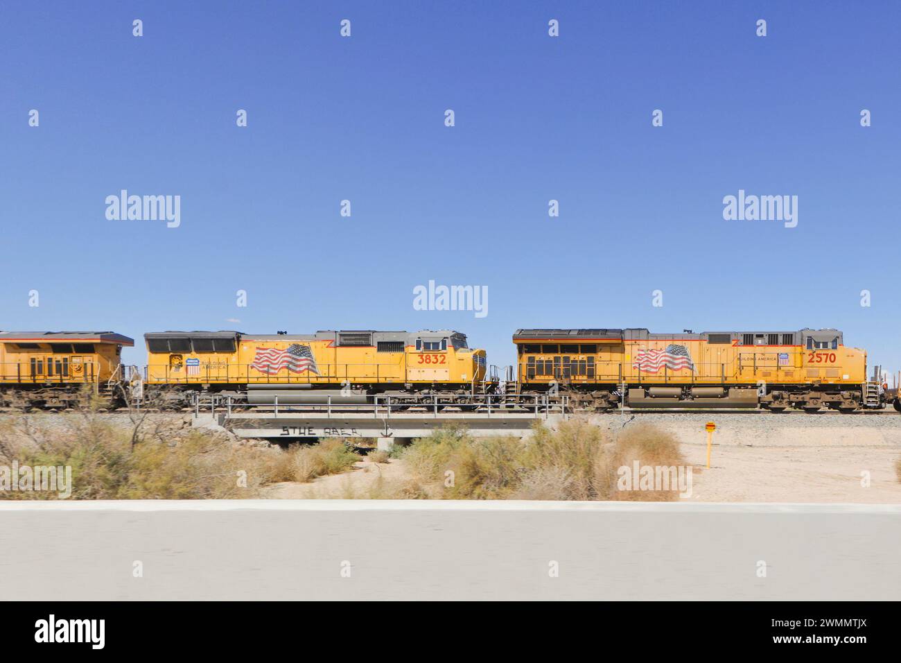 side view of yellow freight train in desert arizona Stock Photo - Alamy