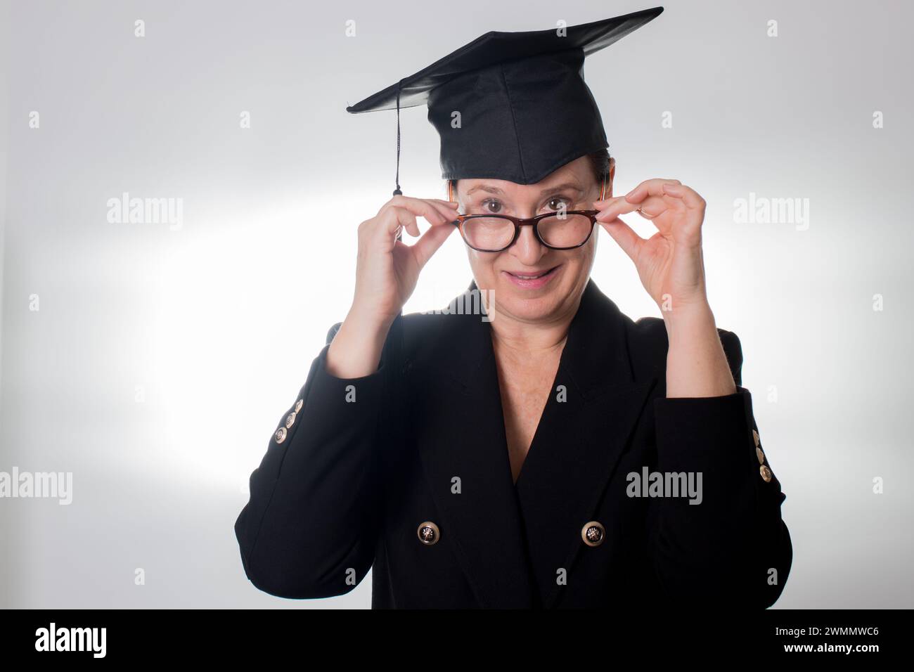 Mature woman with glasses and graduation cap. White background Stock ...