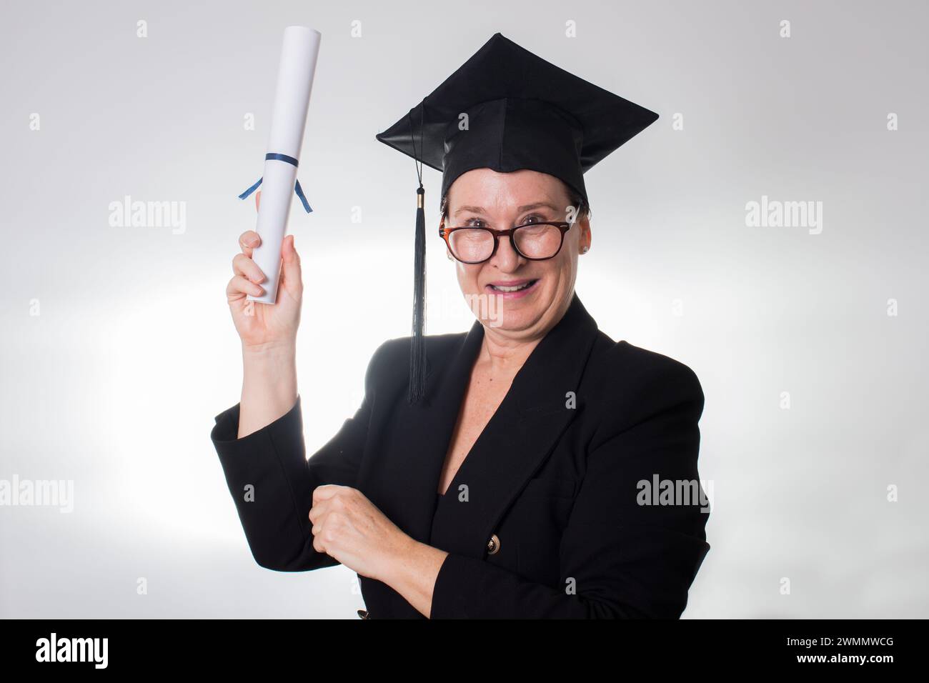 Mature woman with graduation cap showing her certificate. White ...