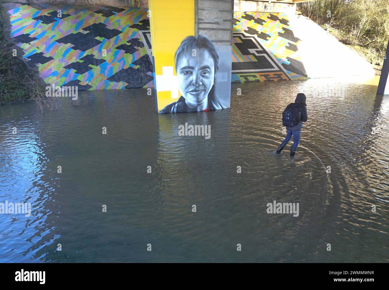 A person walks through floodwater after he River Nene breached its ...