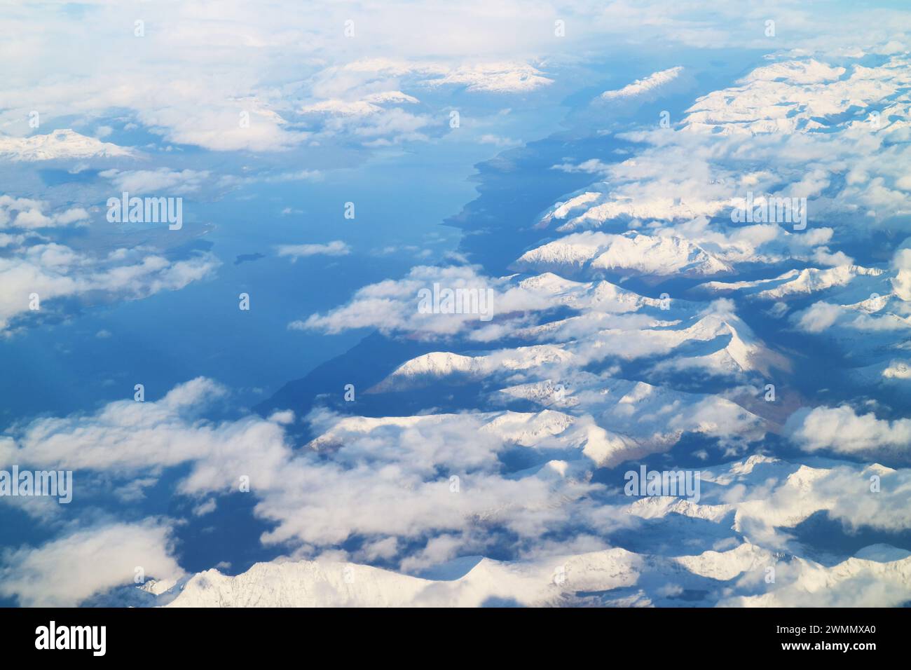 Aerial view of snow capped mountain ranges view from airplane window during the flight ...