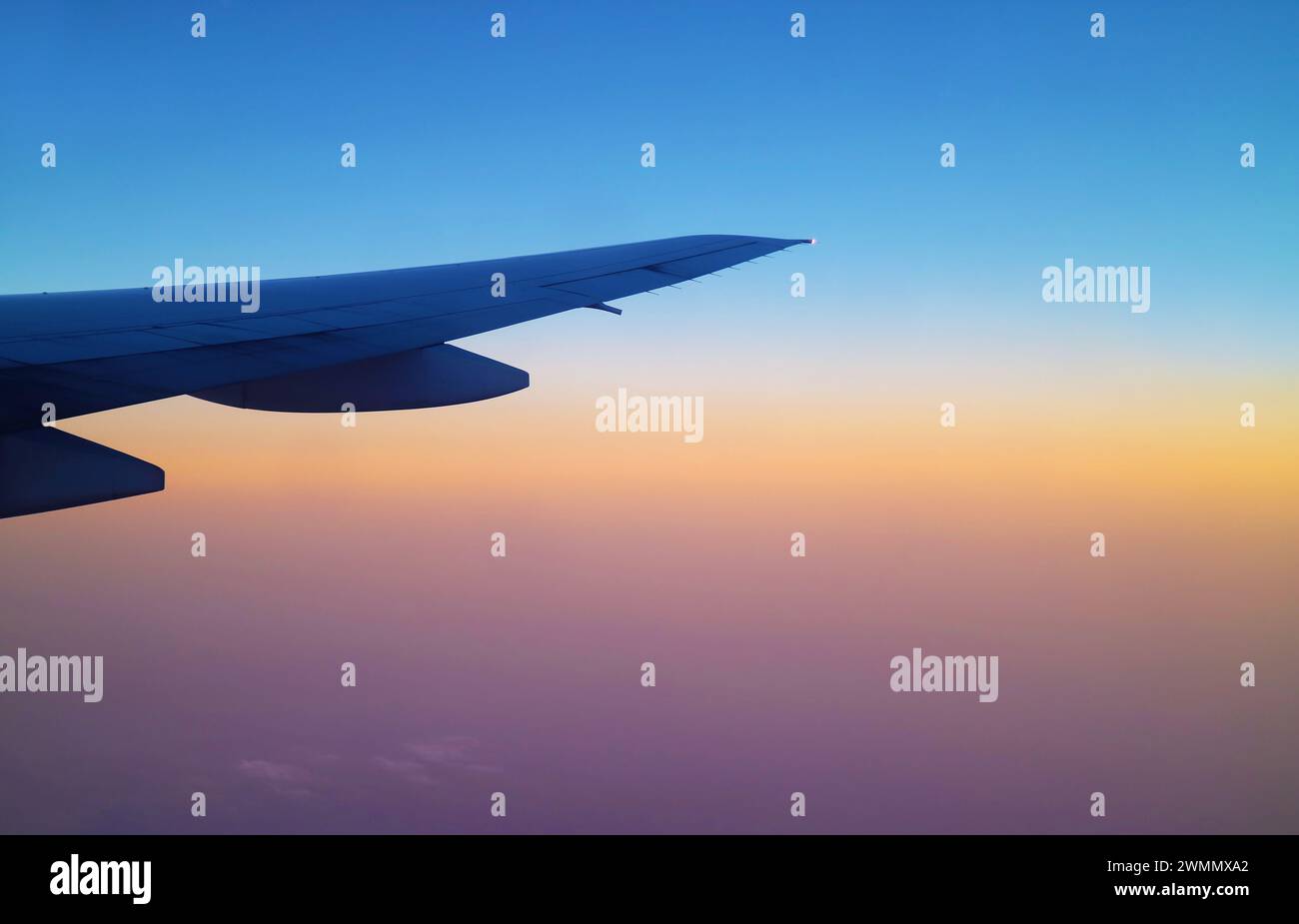 Stunning sunrise sky with airplane wing seen from plane window during ...