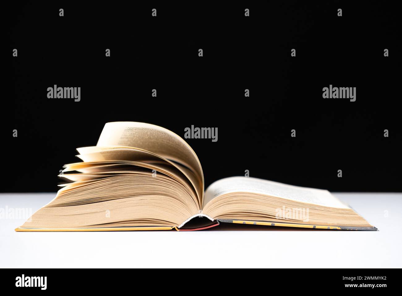 Pages of a thick book are turned on a white and black background, space ...